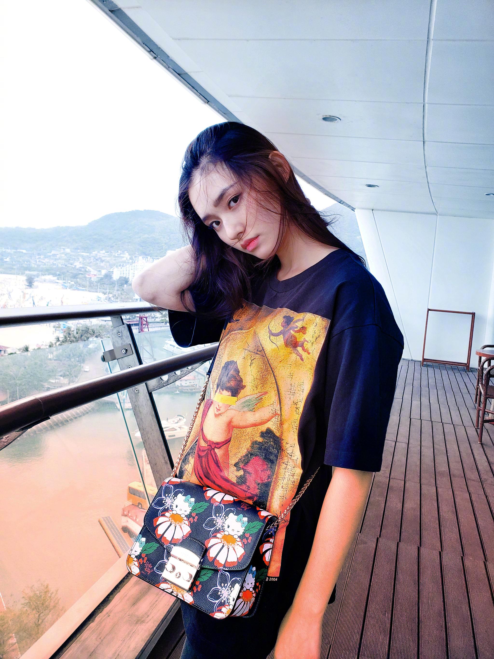 私服，身穿的是Mo&Co 复古T恤，背的是 Hello Kitty系列包款